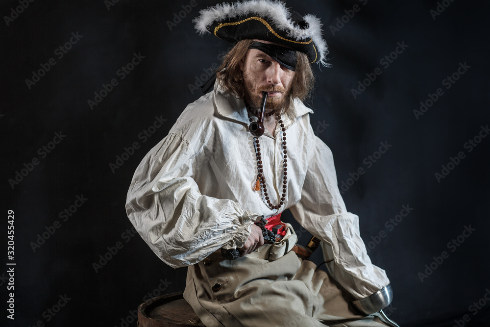 medieval bearded pirate with a sword and gun. concept photo of handsome ...
