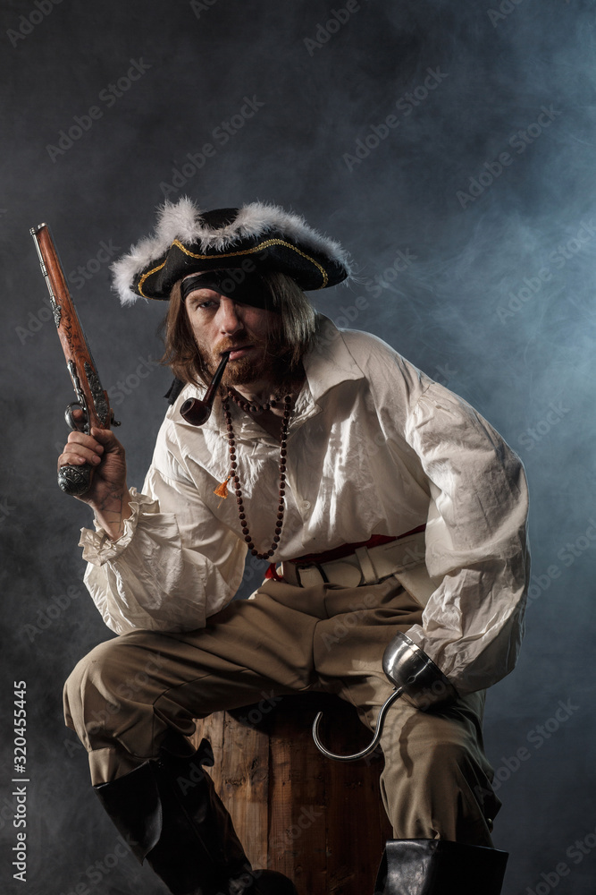 medieval bearded pirate with a sword and gun. concept photo of handsome ...