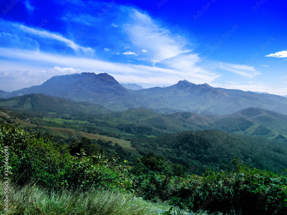 Western Ghats mountains region with blue sky and Munnar tea plantation ...