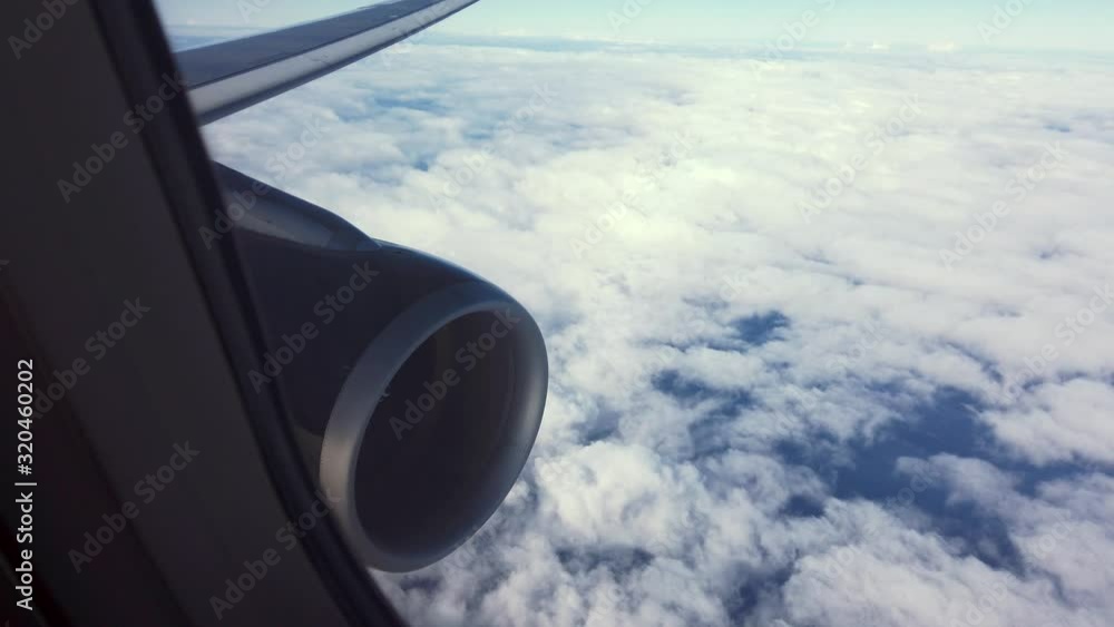 Looking out the airplane window at the engine and wing flying over the ...