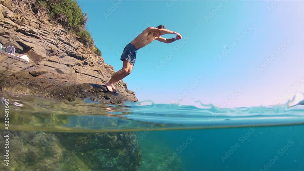 Young Man Jumping off Cliff in Water Doing Somersault. Diving into Blue Sea Water. Extreme ...