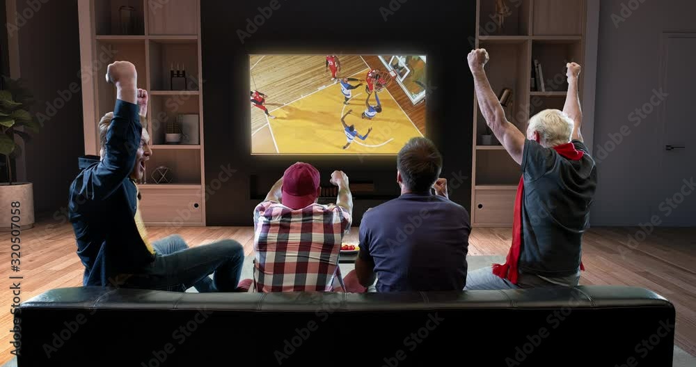 Group of fans are watching a basketball moment on the TV and ...