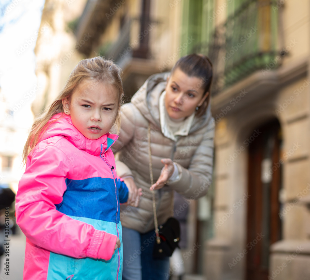 Angry naughty girl with worried mother outdoors Stock Photo | Adobe Stock