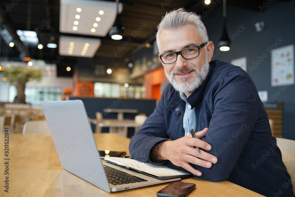 Salesman in restaurant working on laptop computer Stock Photo | Adobe Stock