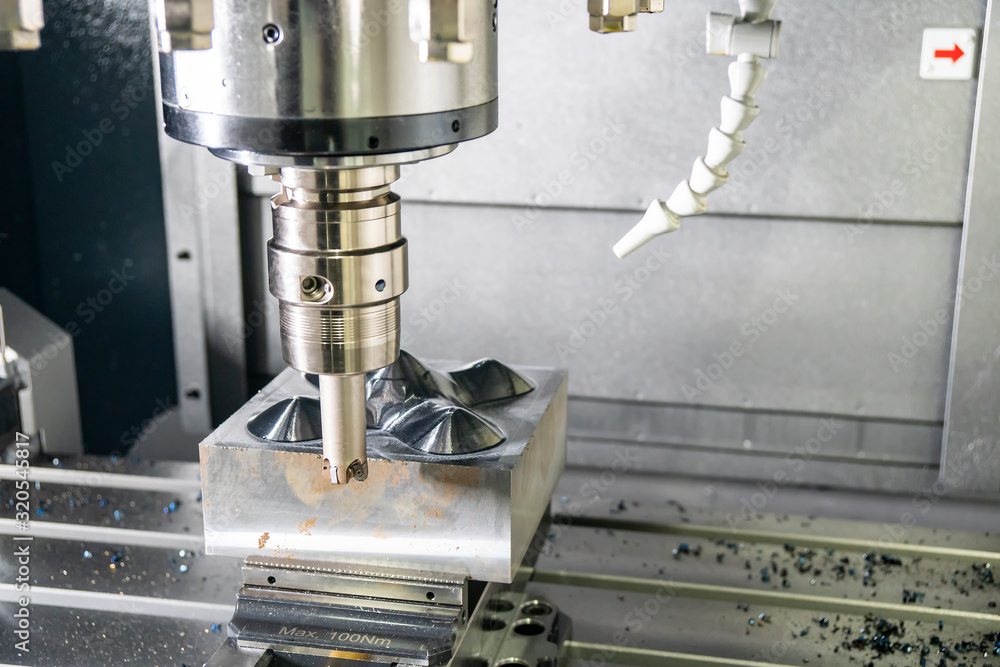 The CNC milling machine rough cutting the injection mold parts by ...