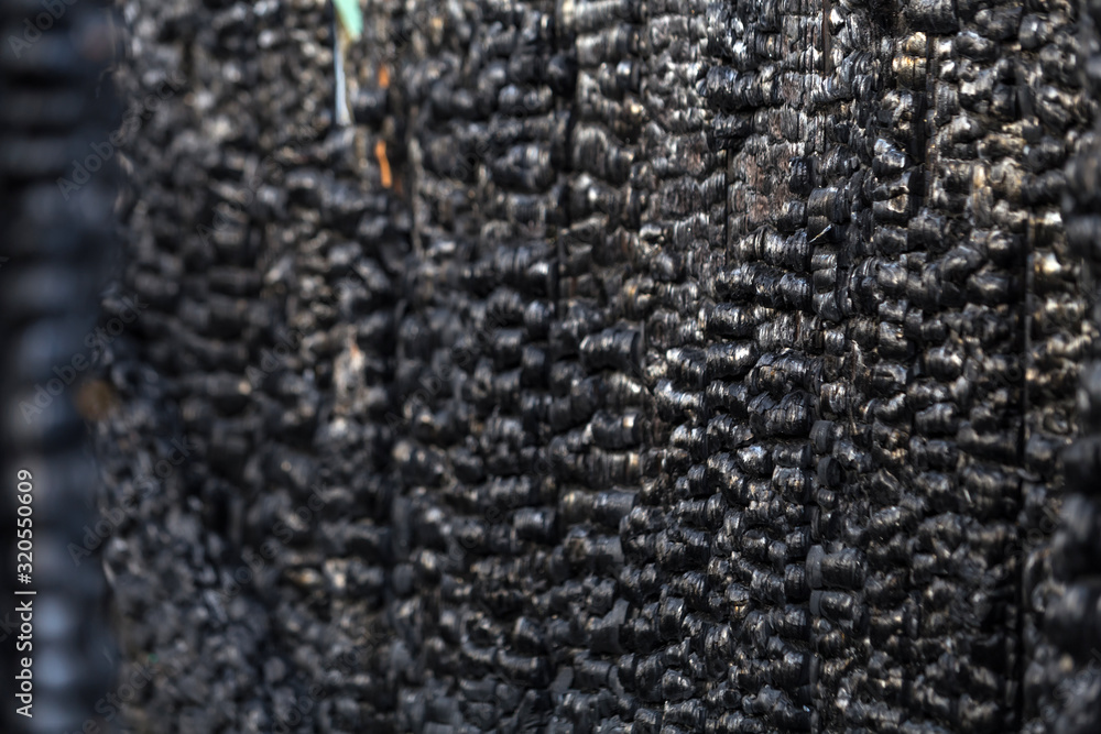 Charred boards in a vertical position. The inner wall of a wooden ...