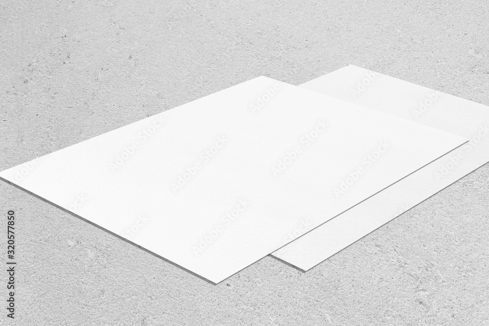 Closeup of two empty white rectangle horizontal poster mockups lying ...