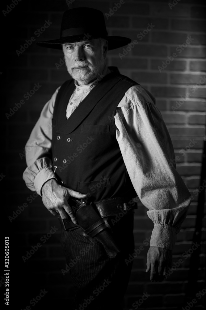 1885 old west cowboy ready to draw his pistol looking at camera medium ...
