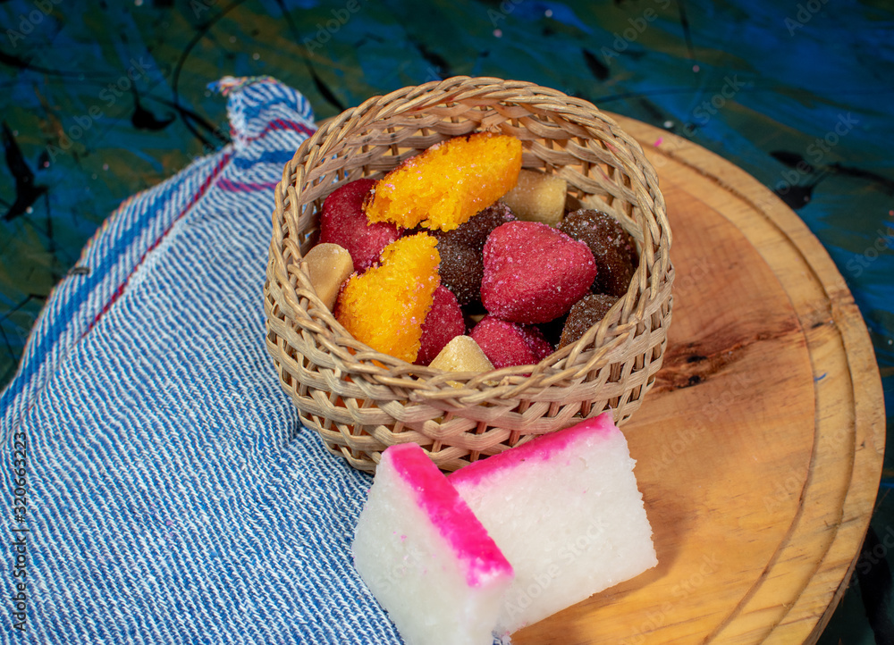 Wicker basket filled with typical Mexican sweets on a wooden board ...