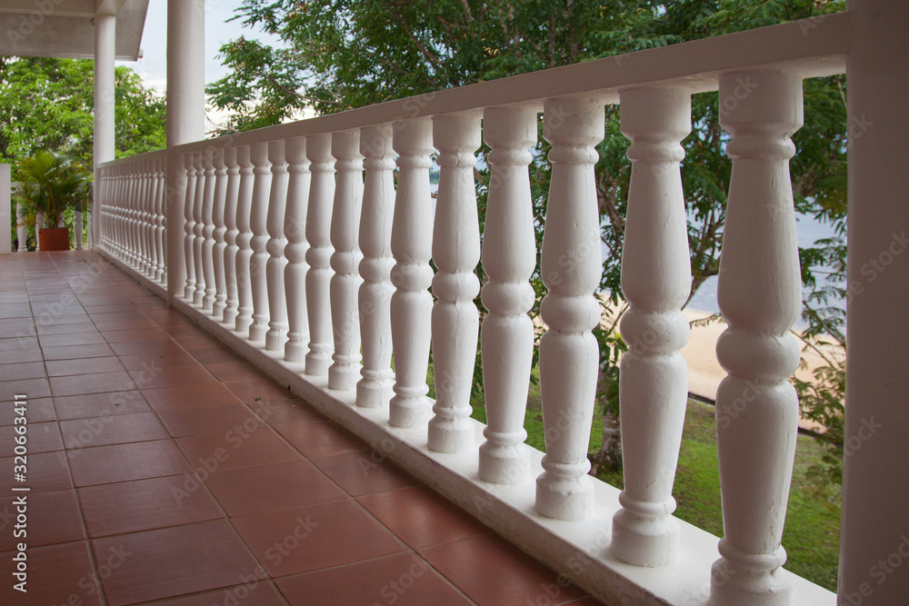 View of the balustrade of the verandah made of white turned wooden ...