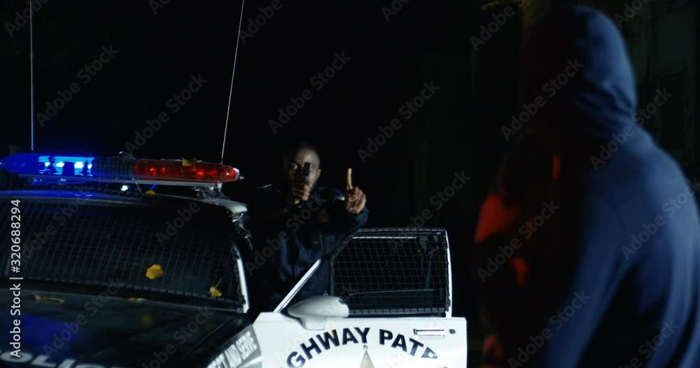 Back view of the criminal at night outdoors. African American police ...