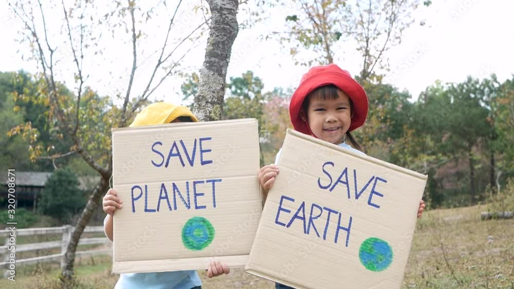 Two little child girl siblings holding "Save the planet" Poster showing ...