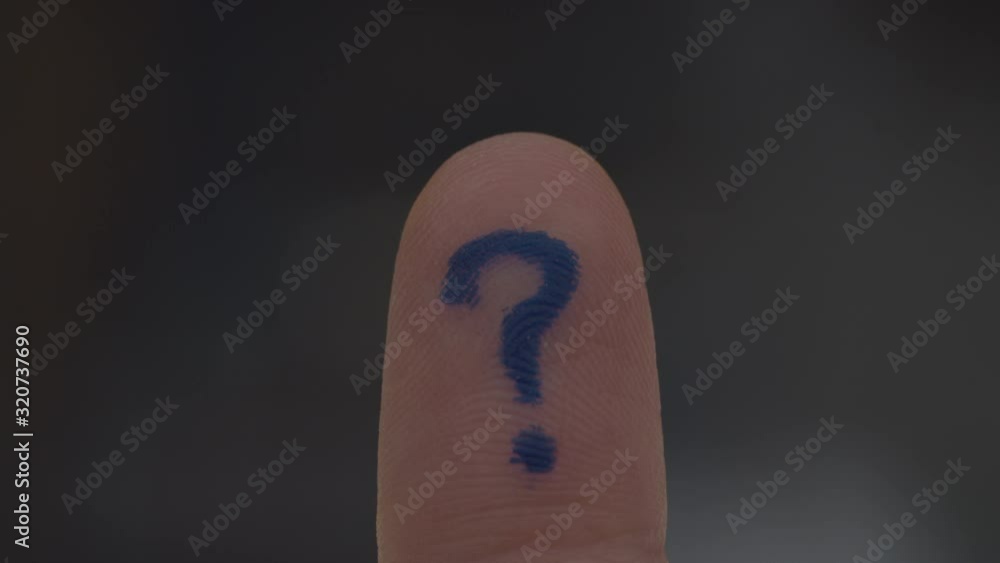 Human finger with written question mark on finger pad rising. Macro ...