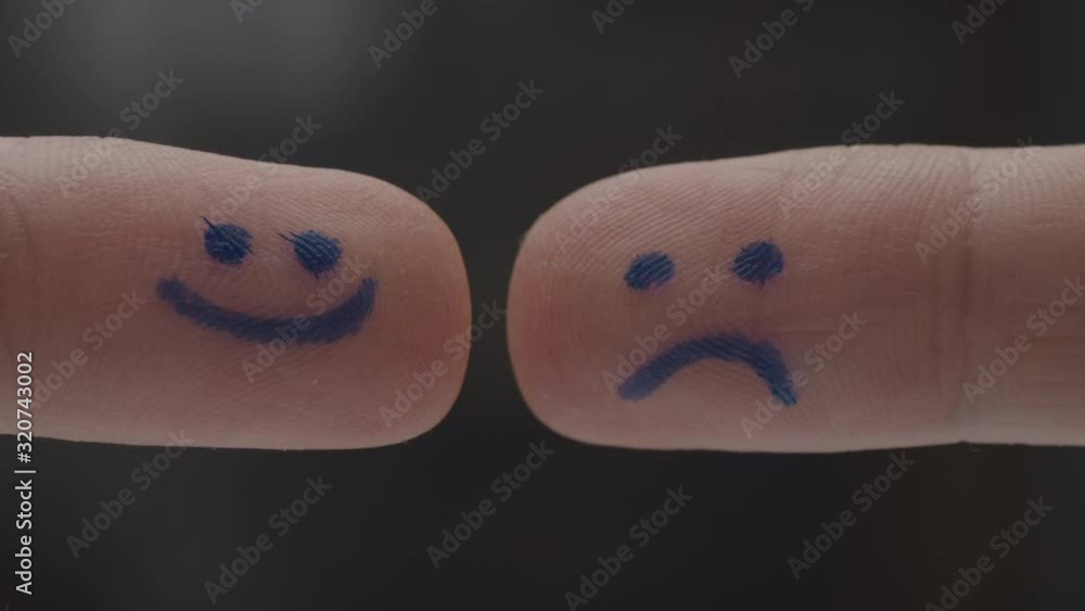 Two fingers with happy and sad smileys on finger pads meeting each ...