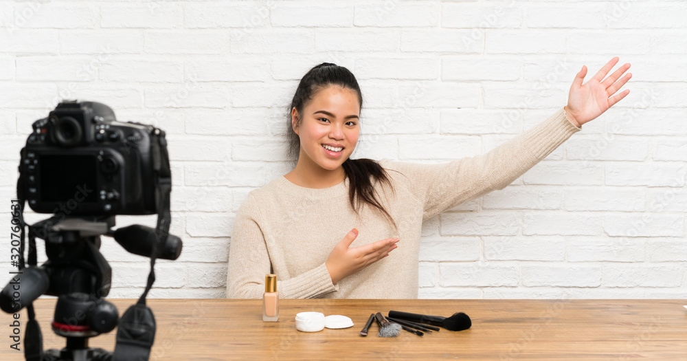 Young blogger Asian girl recording a video tutorial extending hands to ...