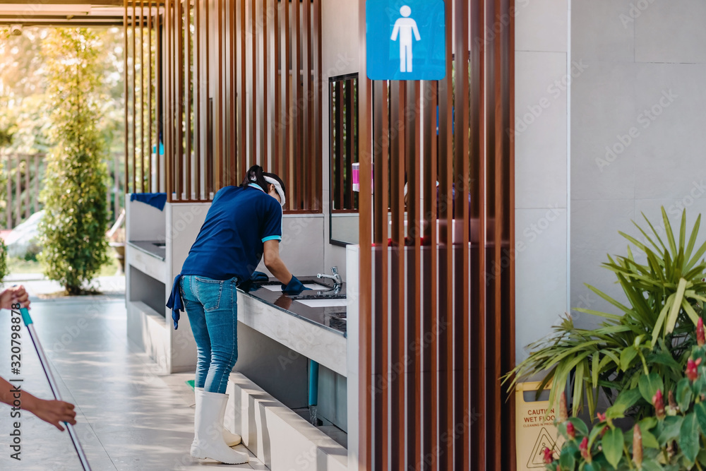 Female janitor using fabric and a detergent cleaning sink and tap in ...