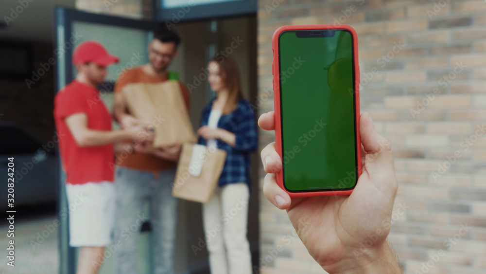Food delivery services. View of young man using smartphone in front of ...