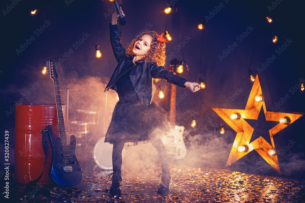 Beautiful girl with curly hair wearing leather jacket, boots sing into ...