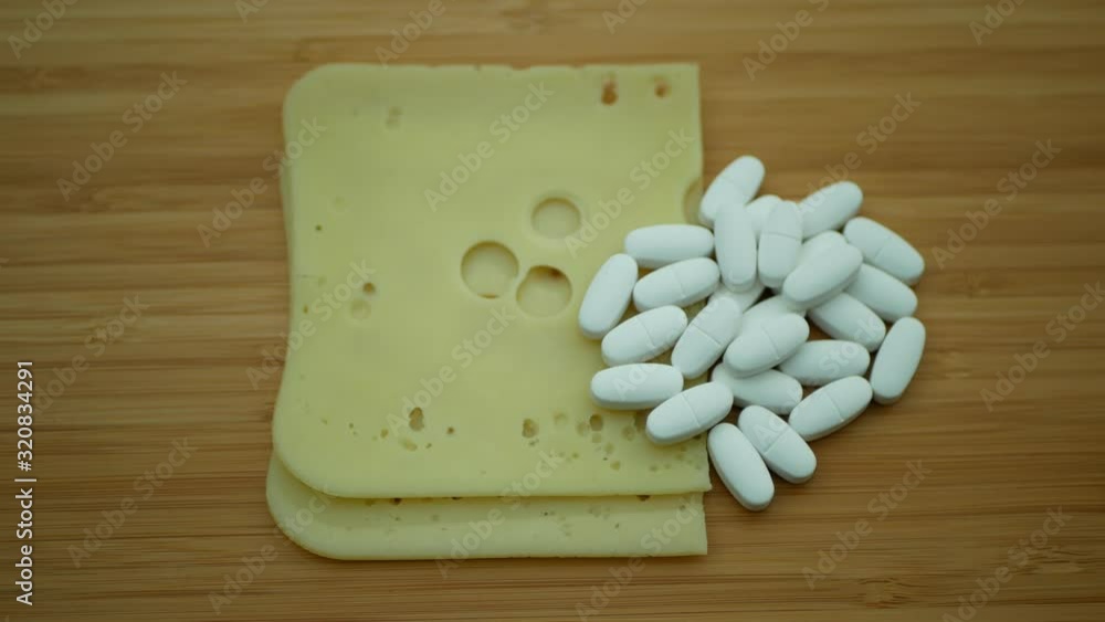 Calcium tablets pills medical capsules white pile and Emmentaler hard ...