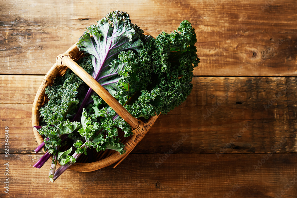 Green and purple leaves of Kale in a basket on a small table Organic ...