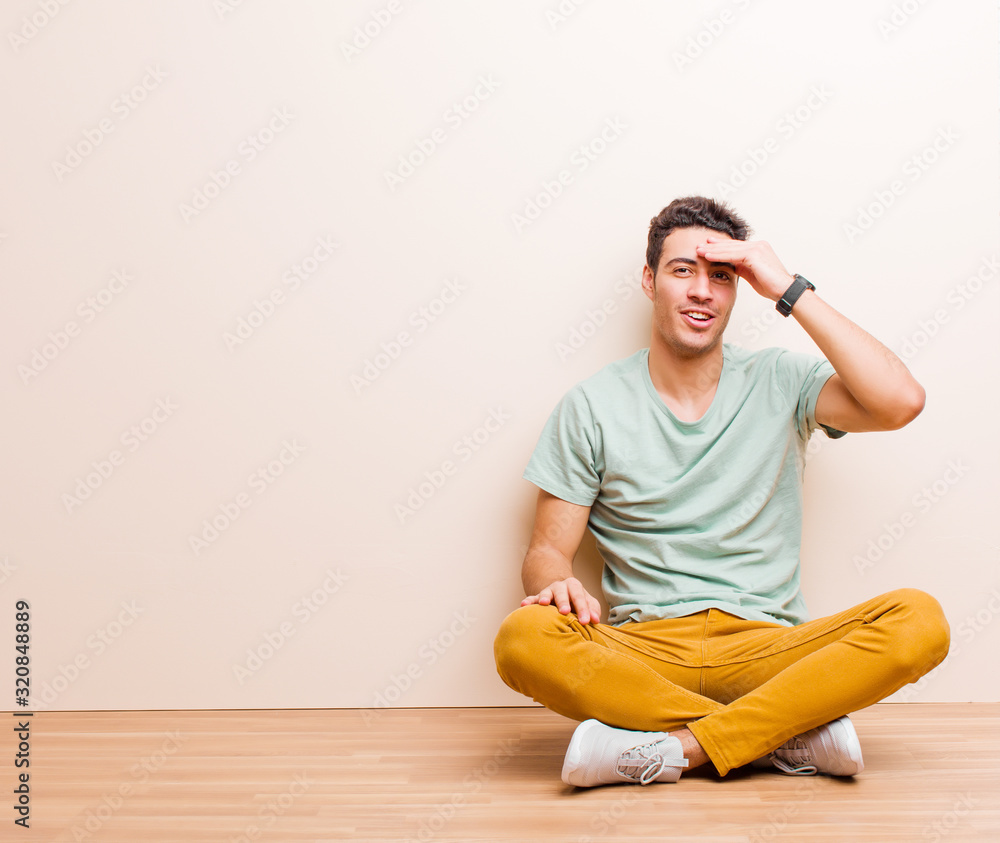 young arabian man looking happy, astonished and surprised, smiling and ...