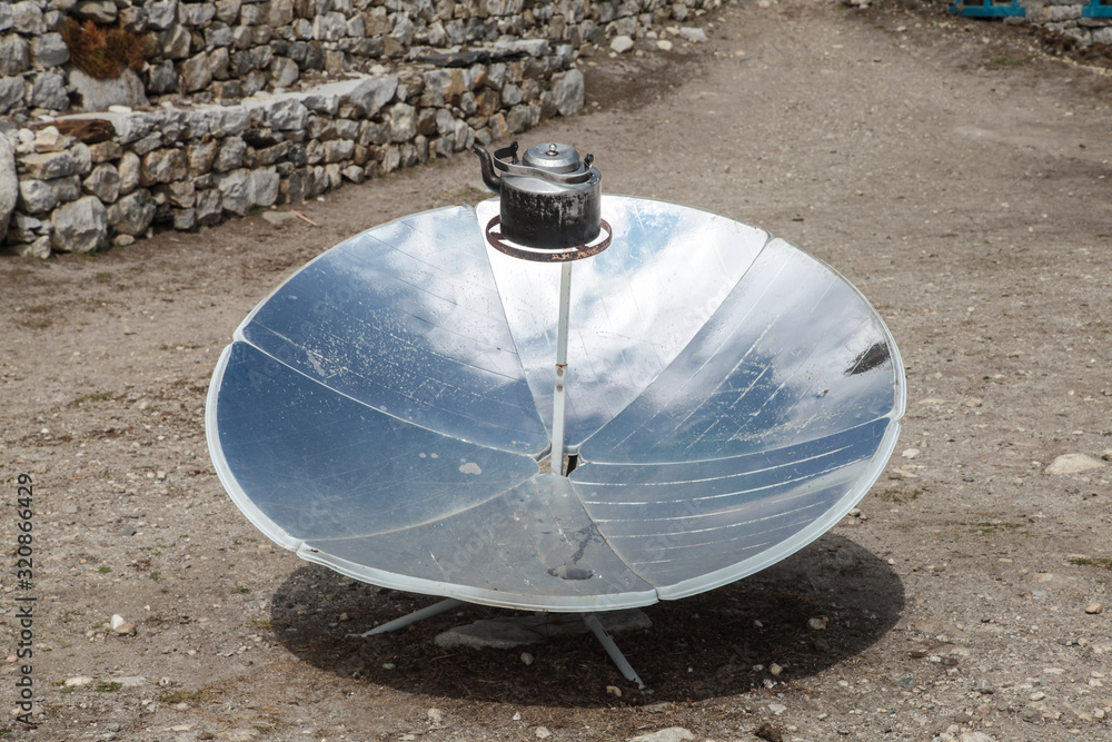 Warming the teapot in a solar cooker. Ecology concept. Renewable green ...