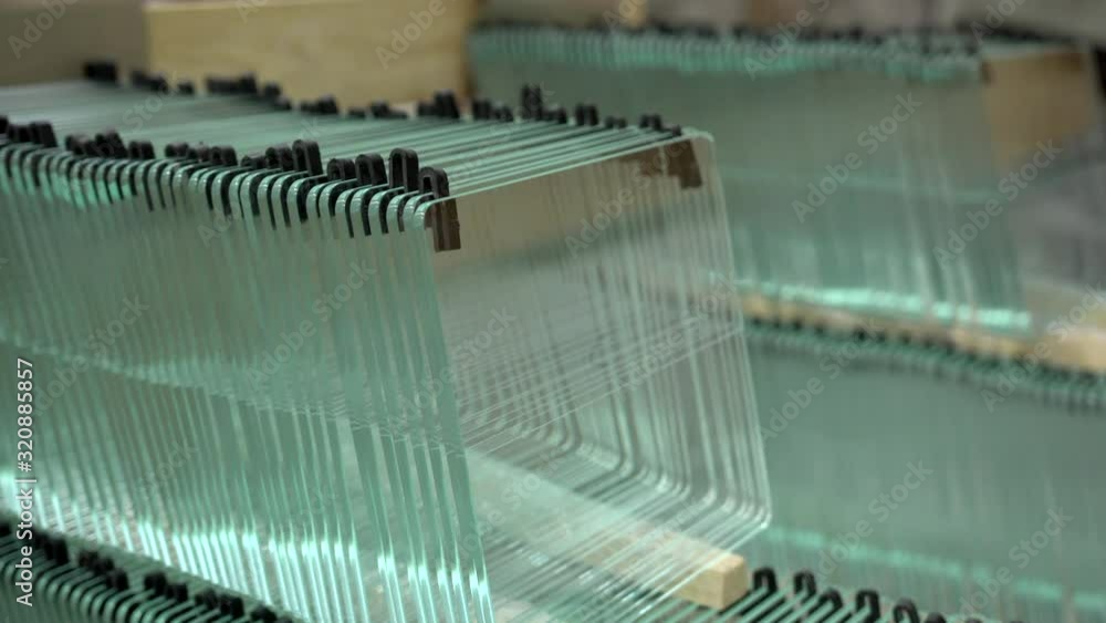 Rows of small square-shaped glass products with rounded corners stacked ...