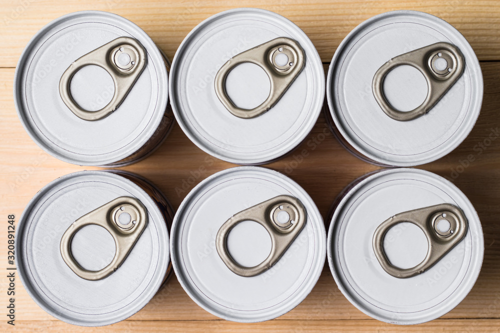 Stack of tin cans with a key, top view. Condensation has formed on the ...