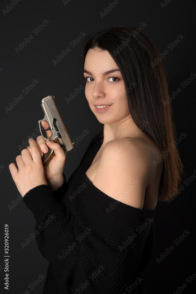 Female assassin with a gun Stock Photo | Adobe Stock