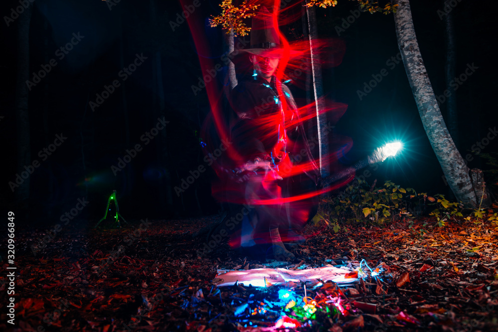 Wizard (mage) casting a spell with his magical staff while standing in ...