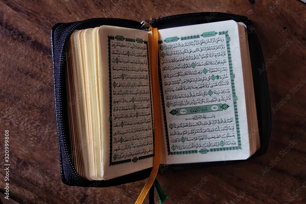 Arabic texts in the holy Koran on wooden backgrounds, open pages of ...