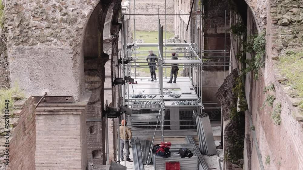 People restoring the ancient ruins over the scaffolds inside the ...