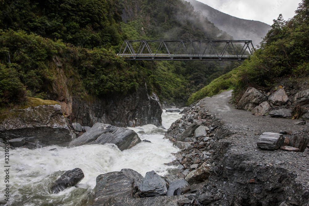 Bridge at Stream. Creek. Rocks. Fast streaming water. Mount Aspiring ...