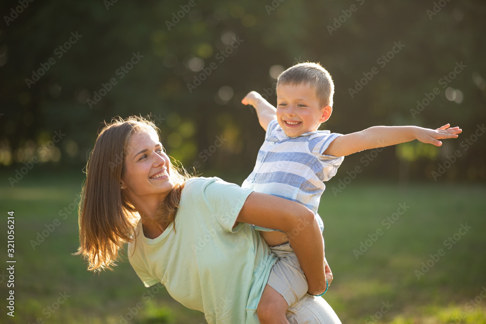 Kid enjoying piggyback ride on mother's back Stock-Foto | Adobe Stock