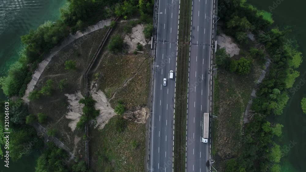 Cars ride on two bridges over the river. The camera is directed ...