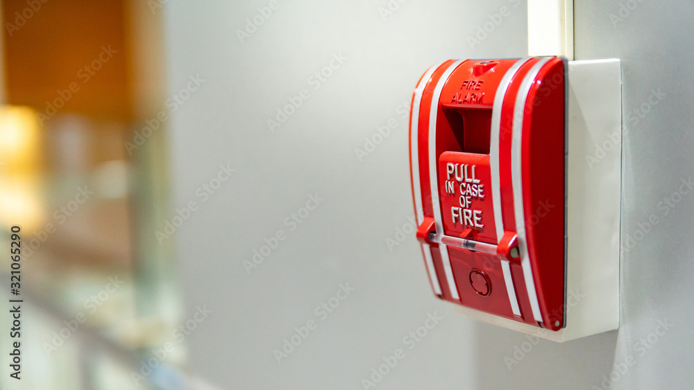 Red fire alarm switch on concrete wall in office building. Industrial ...