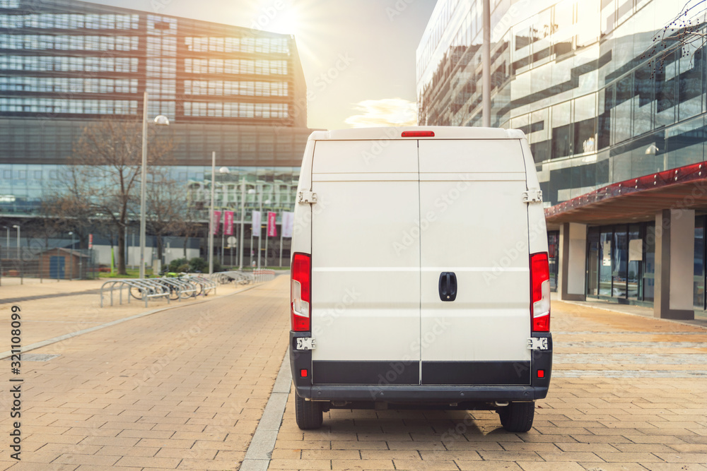 Small cargo delivery van driving in european city central district ...