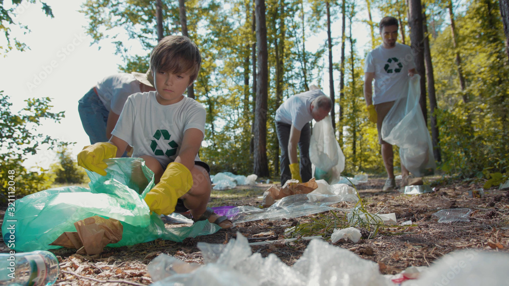 Shot of volunteers activists people in gloves tidying up rubbish in ...