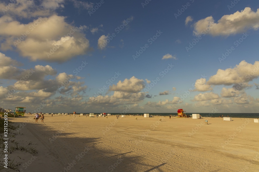 People on Miami Beach relax on sandy beach a beautiful sunny day on the ...