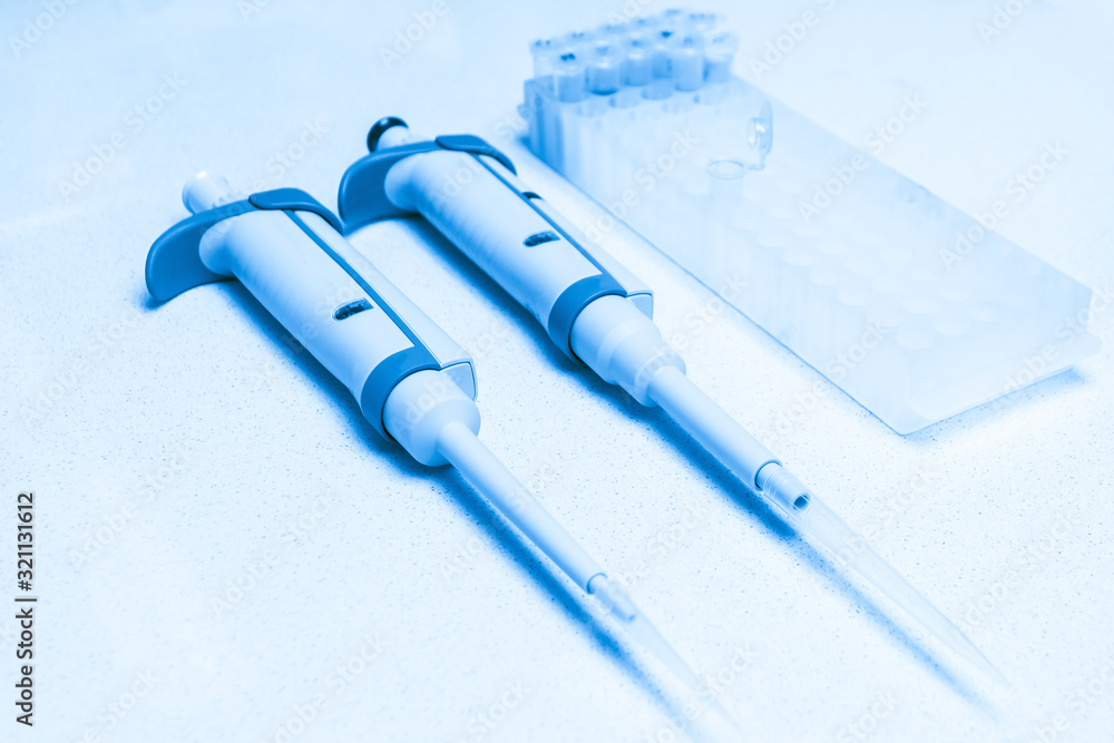 Chemical equipment are on the white background. Automatic pipettes and ...