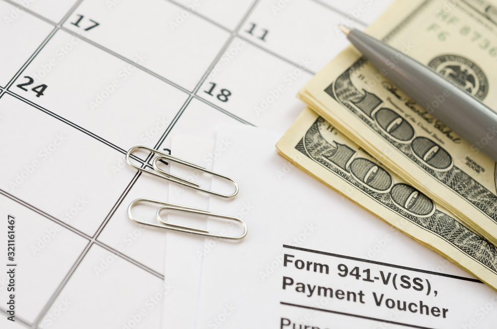 IRS Form 941-V Payment Voucher blank lies with pen and many hundred ...