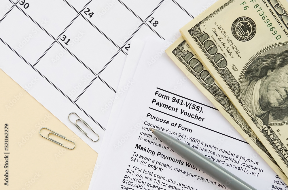 IRS Form 941-V Payment Voucher blank lies with pen and many hundred ...