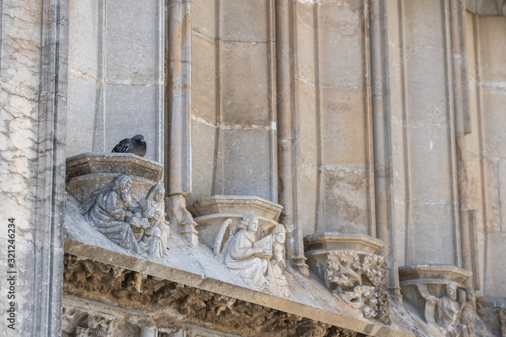 Pigeon sits on element of Gothic architecture. Pinnacles, crabbs and ...
