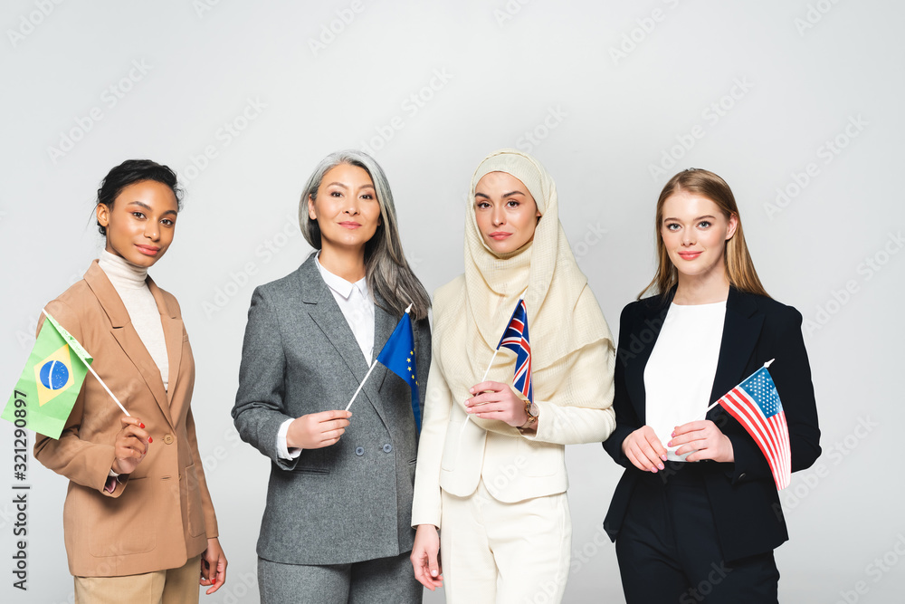 Multicultural women with flags of different countries isolated on white ...