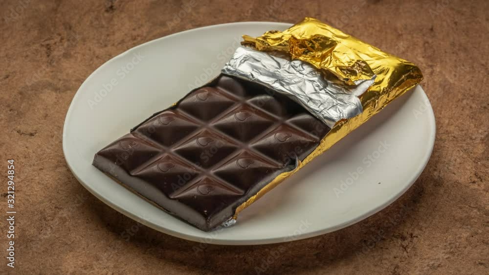 Stop motion animation of dark chocolate bar on a plate - moving ...