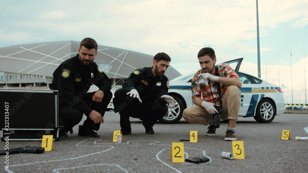 Bottom view police officers and forenscics scientist discussing details ...