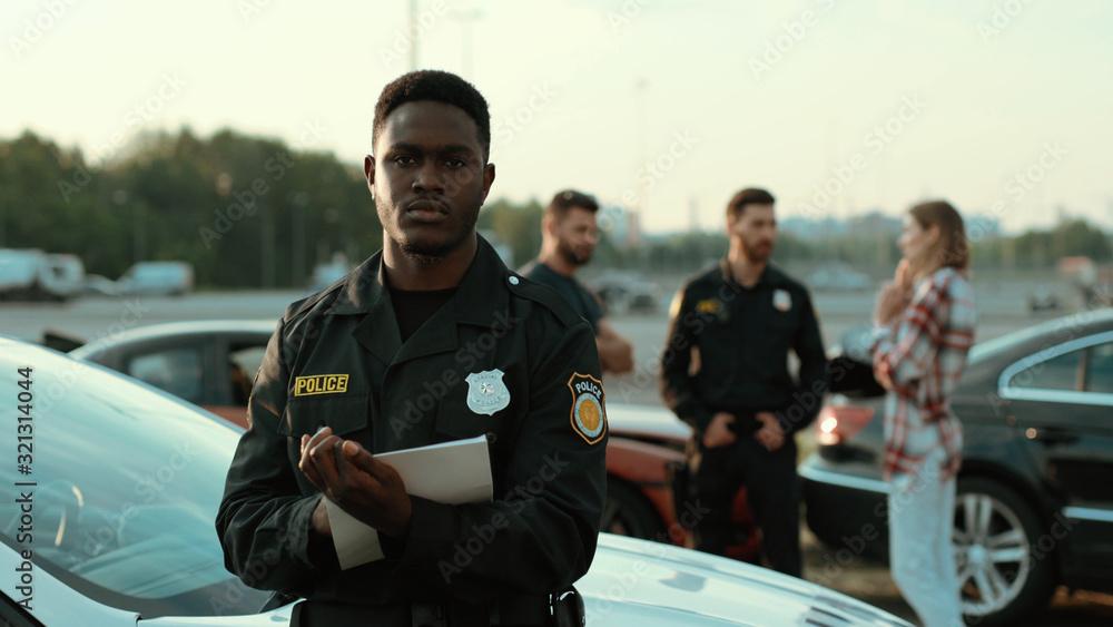 Confident serene african american cop with papers looking on camera ...