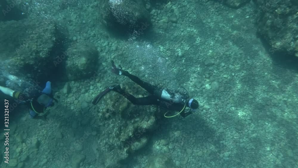 Vidéo Stock beginner scuba diver swims for experienced diving guide ...
