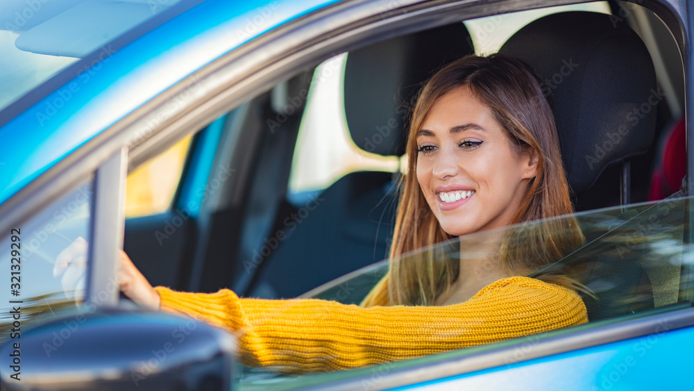Portrait of beauty with toothy smile driving car. Hands on steering ...