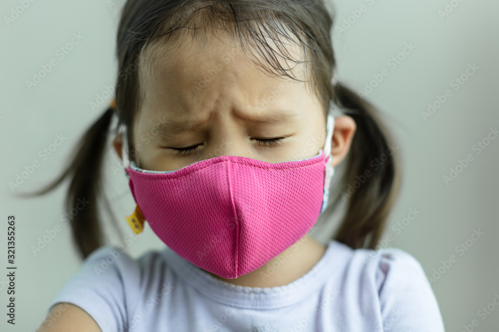 Sick child patient suffering from a virus infection in asia, wearing a ...
